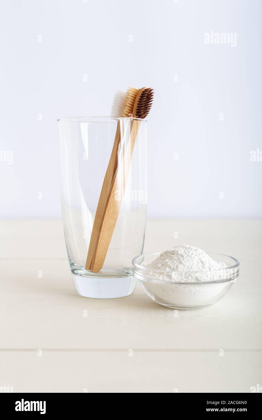 Bamboo toothbrush in glass with dentifrice tooth powder on white ...