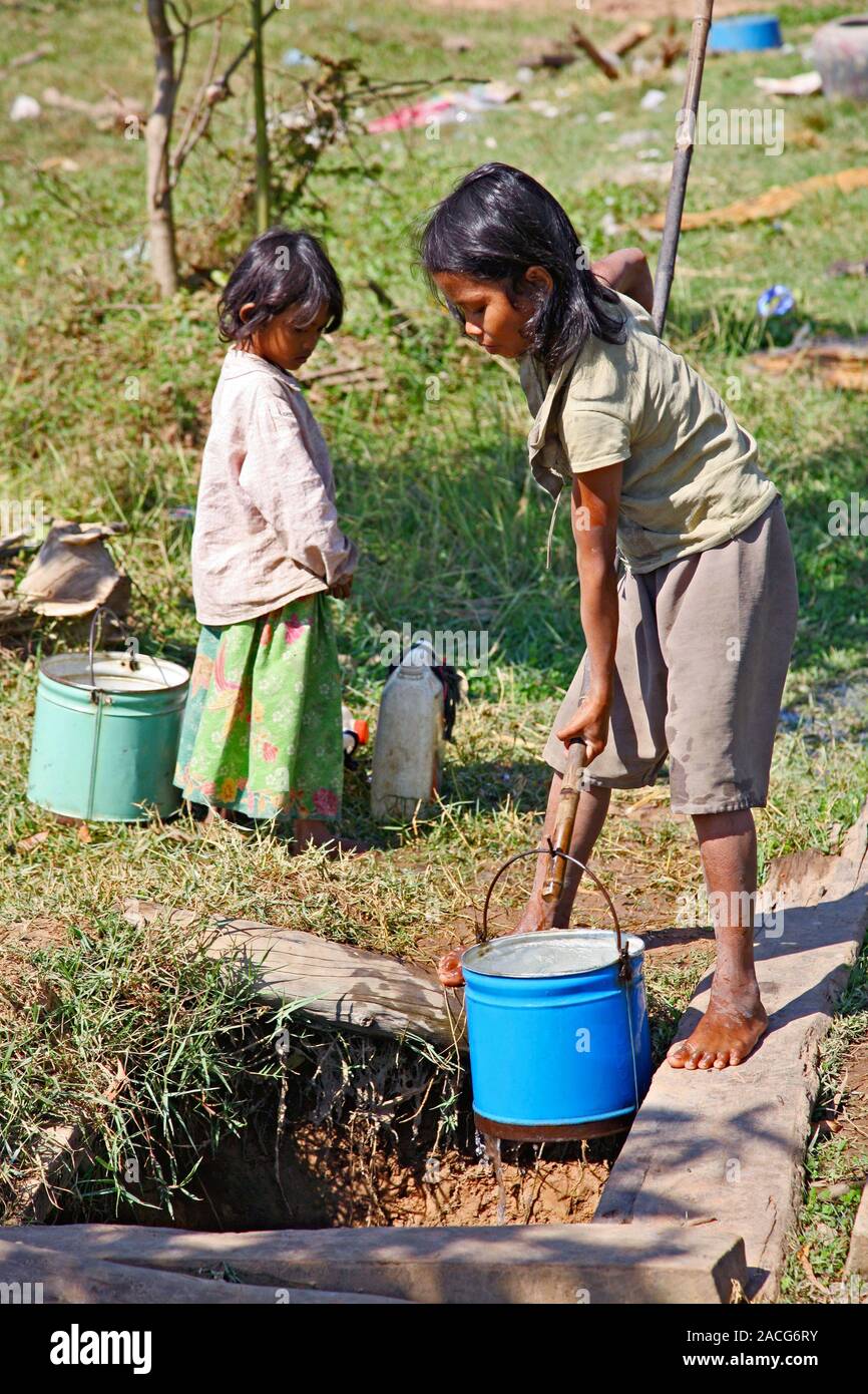Village water well. Children drawing water from a well. In developing ...