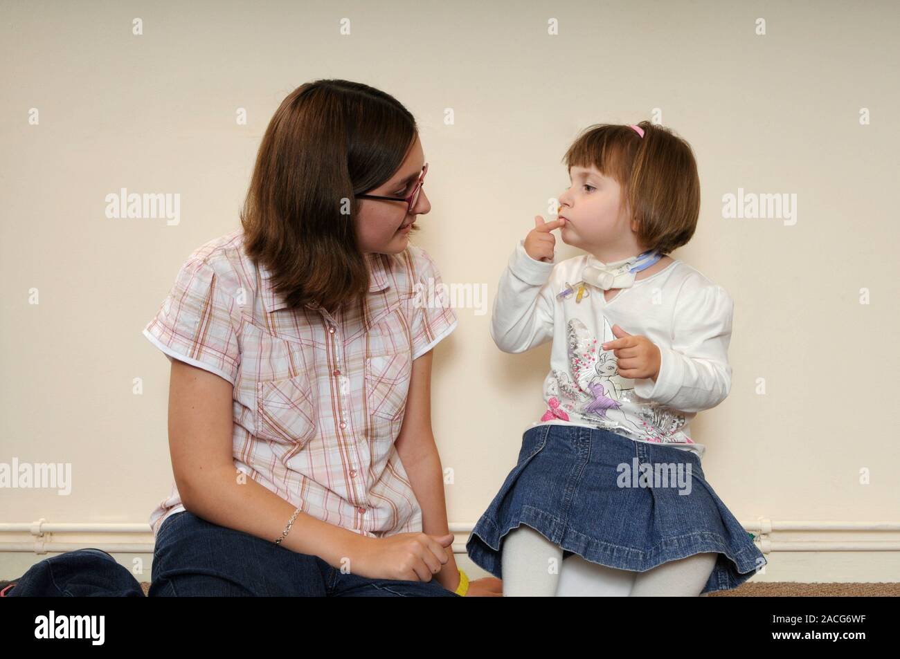 Child with tracheostomy using sign language. Young girl aged 2 1/2 ...