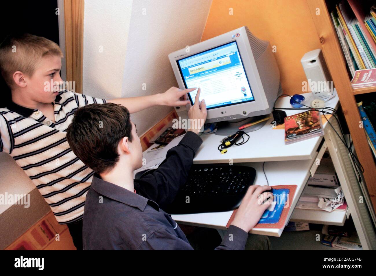Teenage computer use. Young teenagers using an email website on a ...