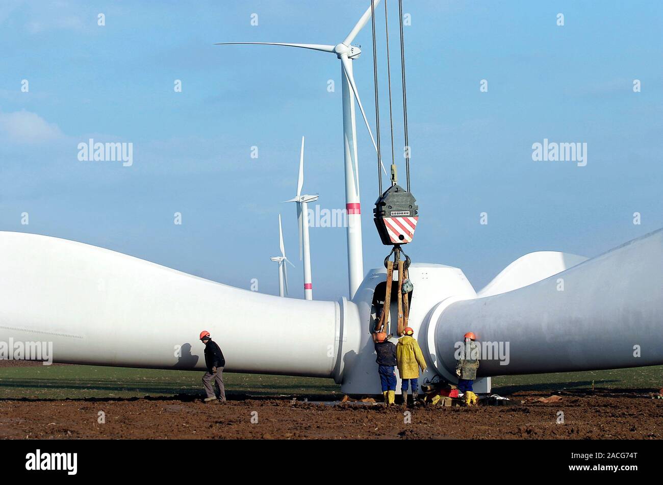 Wind farm construction. Engineers standing next to the giant blades of ...