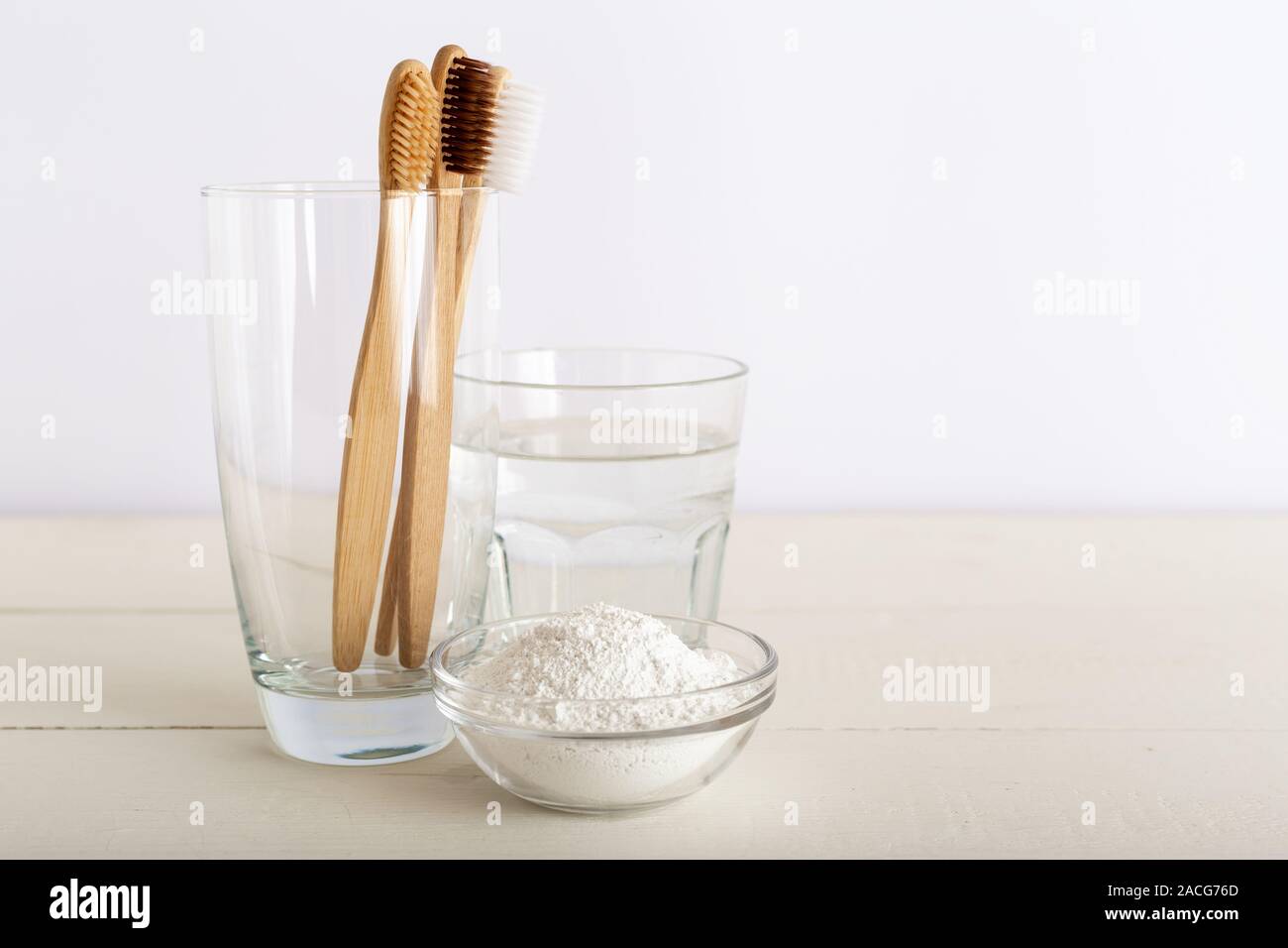Bamboo toothbrushes, glass of water, dentifrice tooth powder on white ...