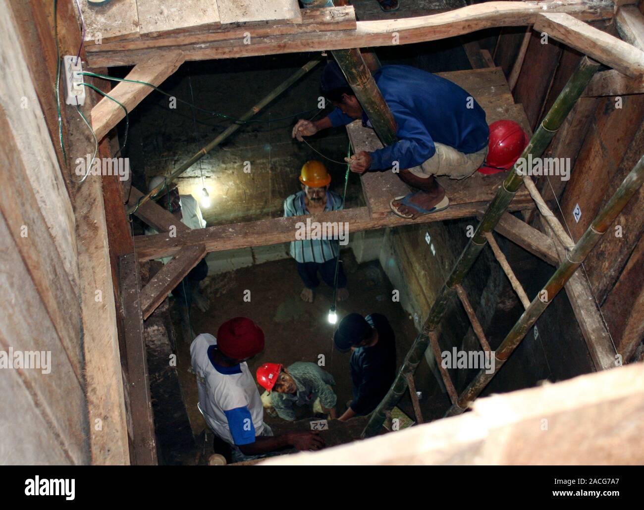 Liang Bua cave exploration. Workers removing earth from the Liang Bua ...