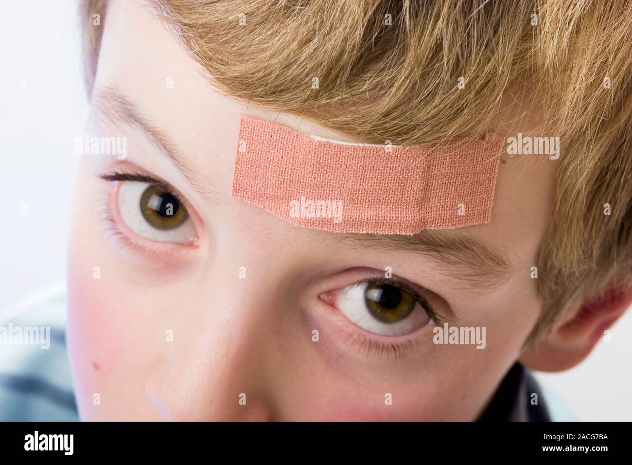 Plaster on a boy's forehead. The plaster protects the wound, helping to prevent infection and ...