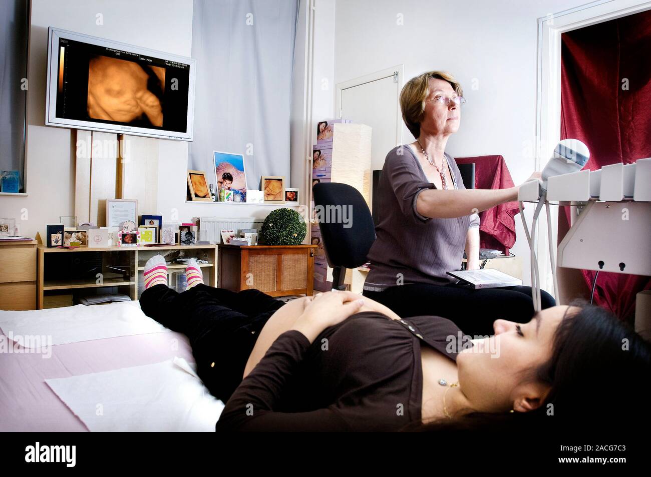Pregnancy ultrasound. Doctor carrying out a 3D real-time ultrasound ...