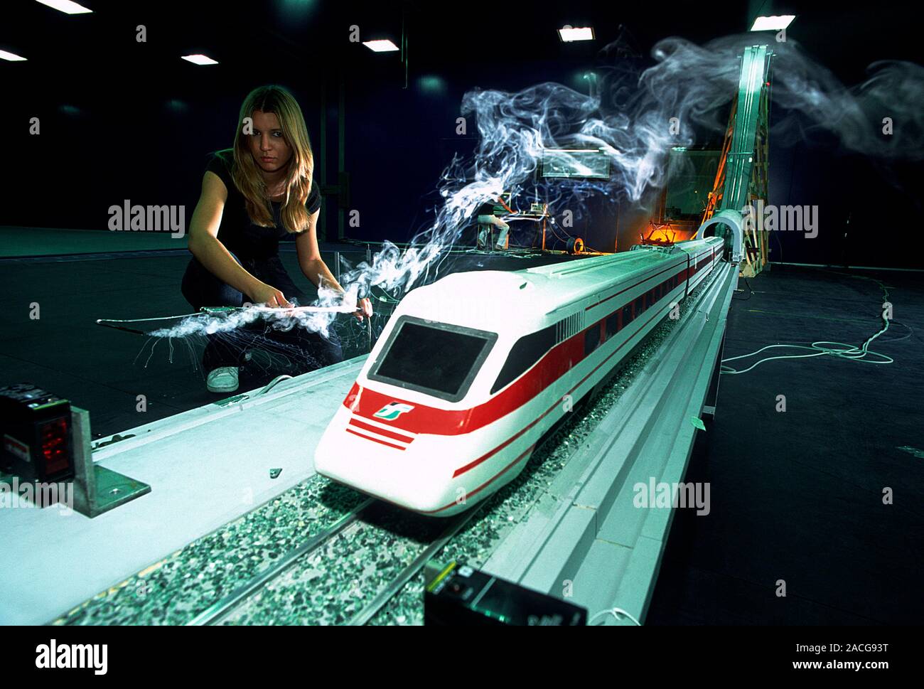 Train wind tunnel test. Researcher with a model high-speed train on a ...