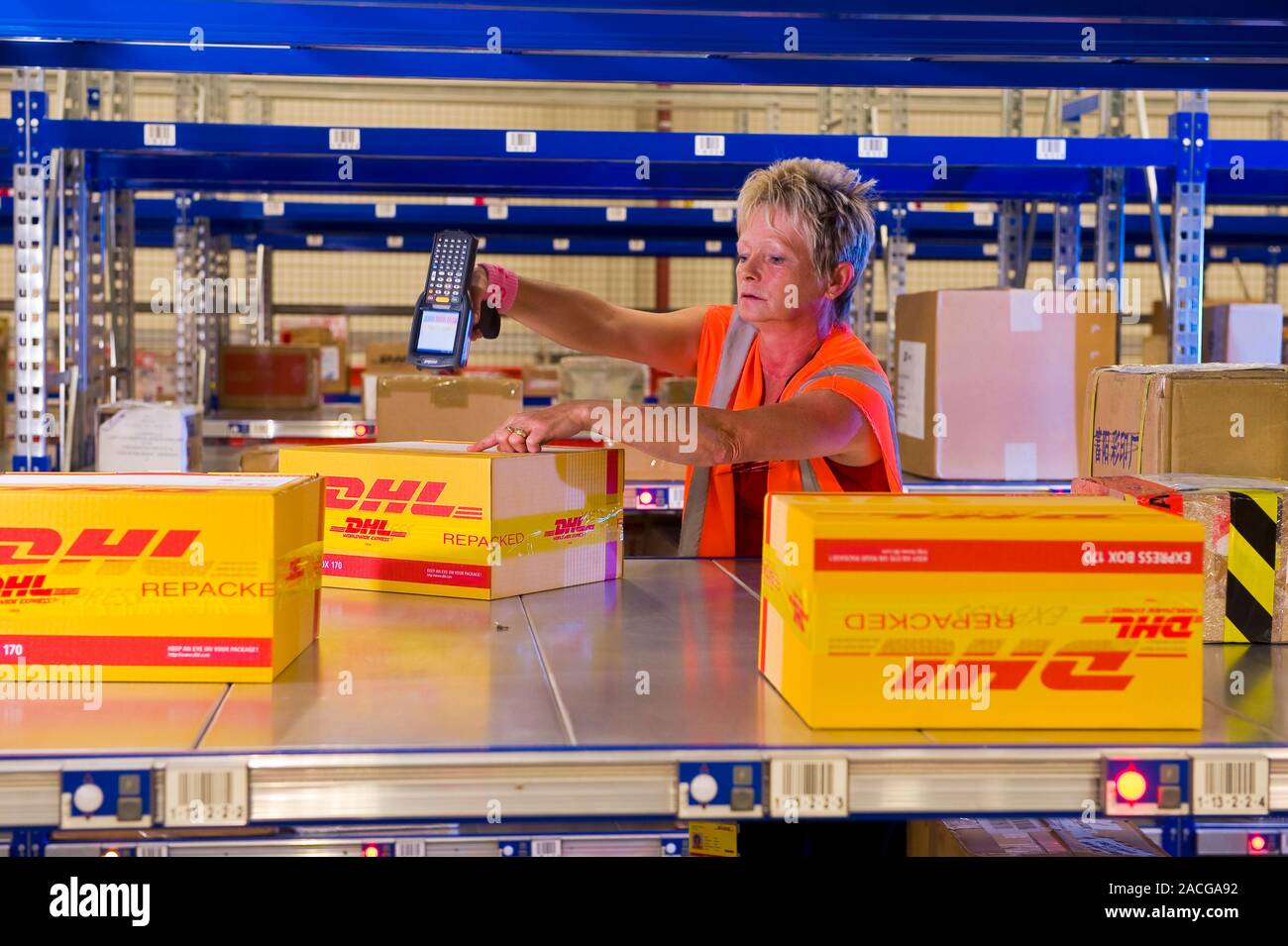 Parcel processing centre. Worker scanning the barcodes of parcels being ...