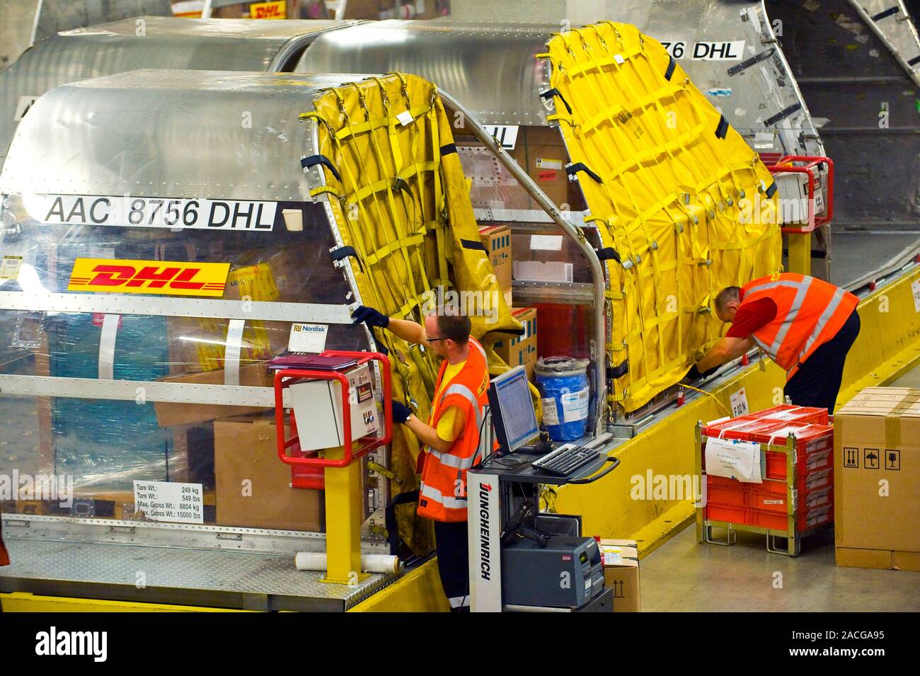 Parcel processing centre. Workers loading airline containers with post ...
