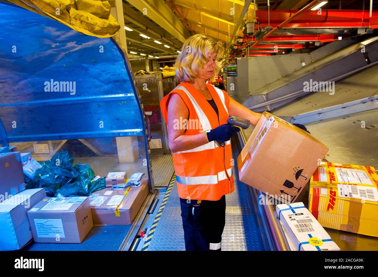 Parcel processing centre. Worker checking parcels with a barcode ...