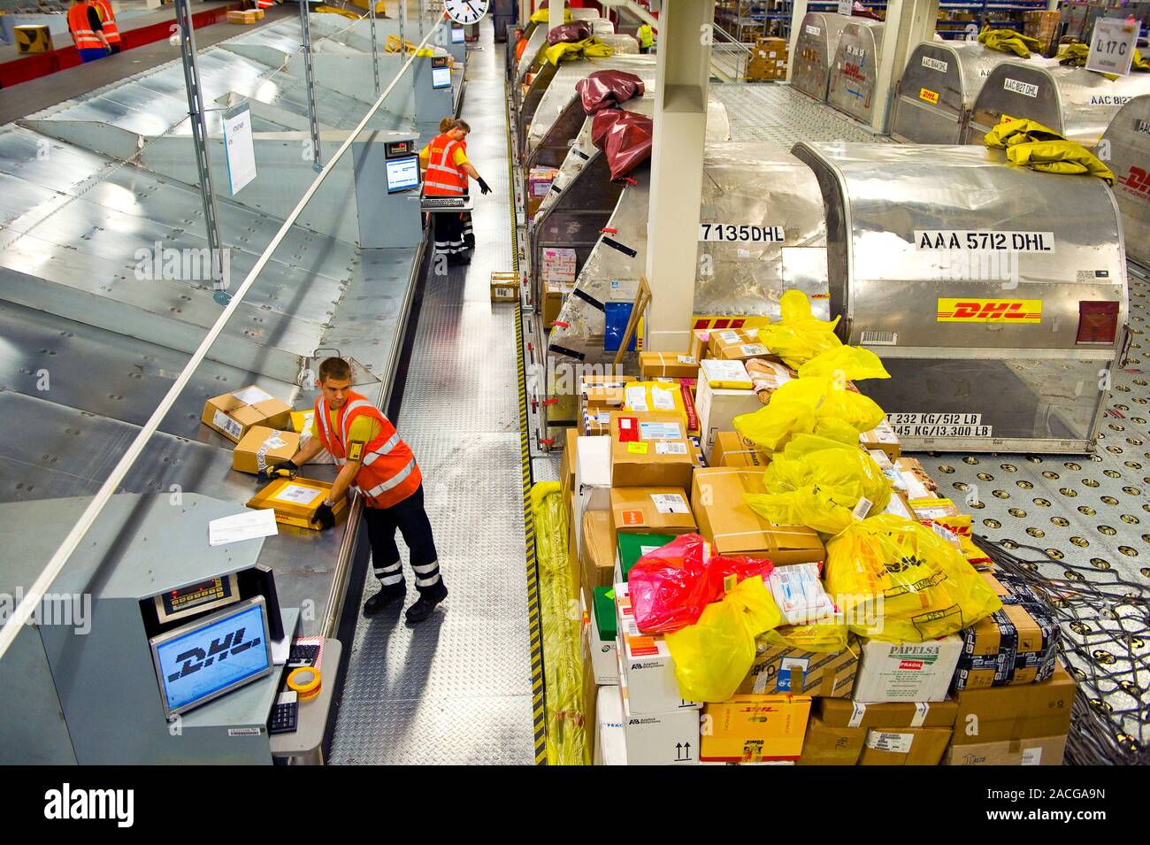 Parcel processing centre. Workers sorting post to be loaded onto ...