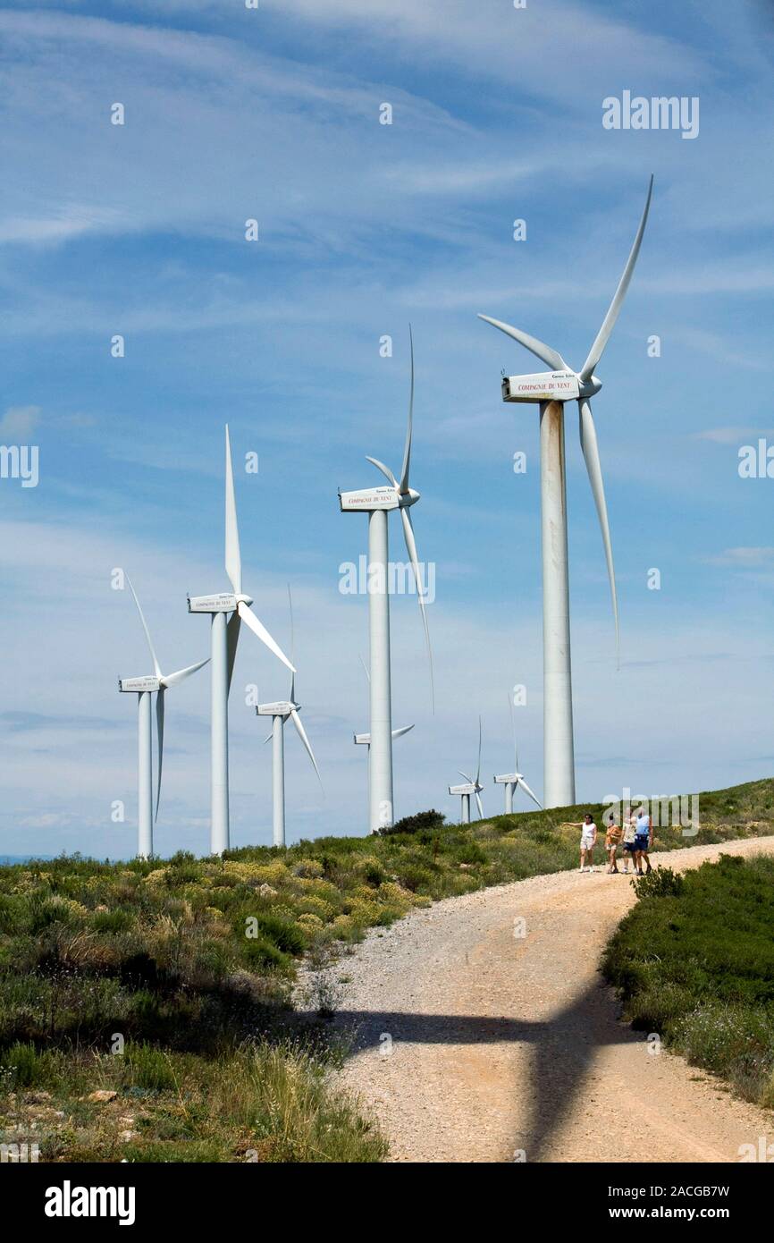 Wind farm. Row of wind turbines along the crest of a hill, with people ...