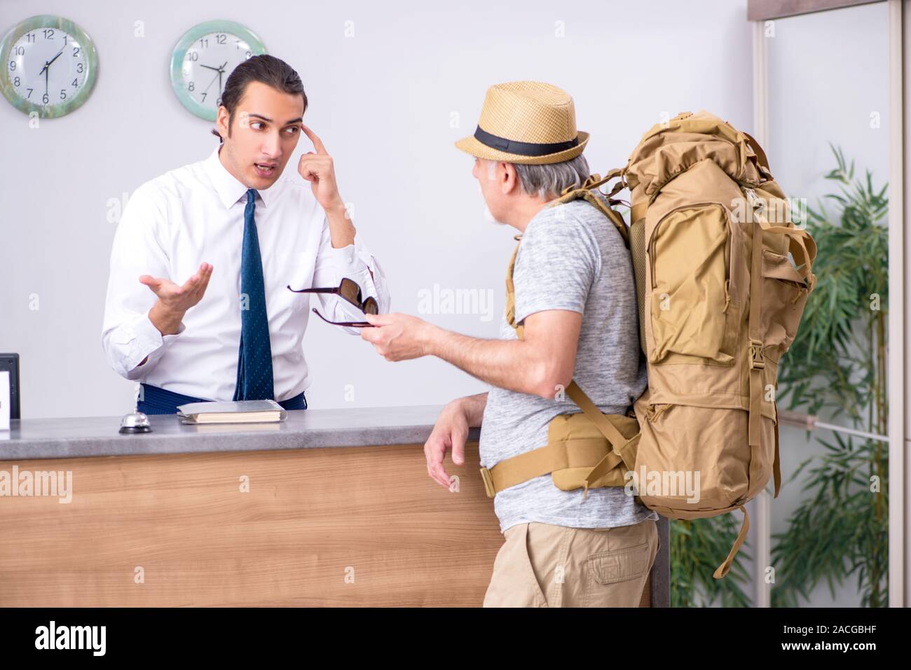 Old backpacker at the hotel reception Stock Photo - Alamy