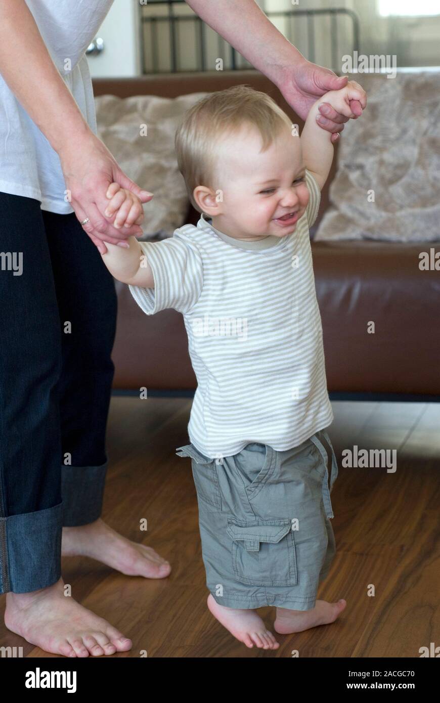 Toddler learning to walk with his mother Stock Photo - Alamy