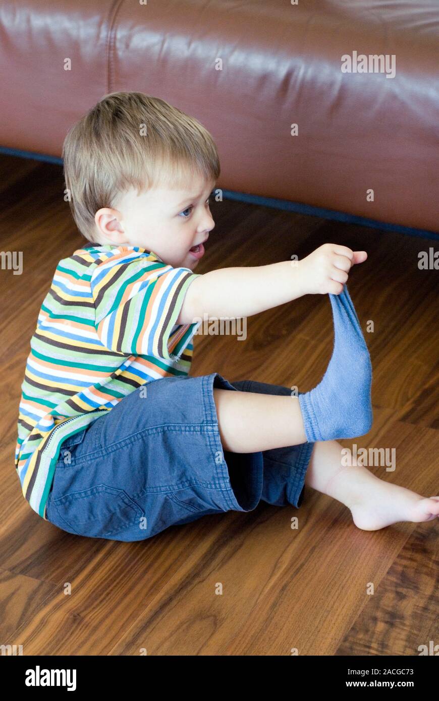 Toddler taking off his socks Stock Photo - Alamy