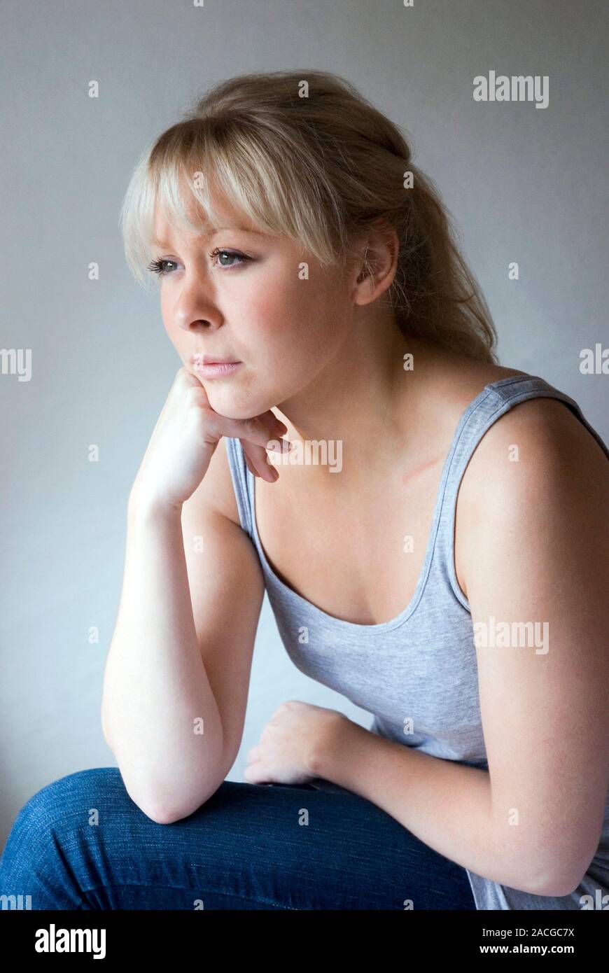 Woman thinking with her head on her hand Stock Photo - Alamy
