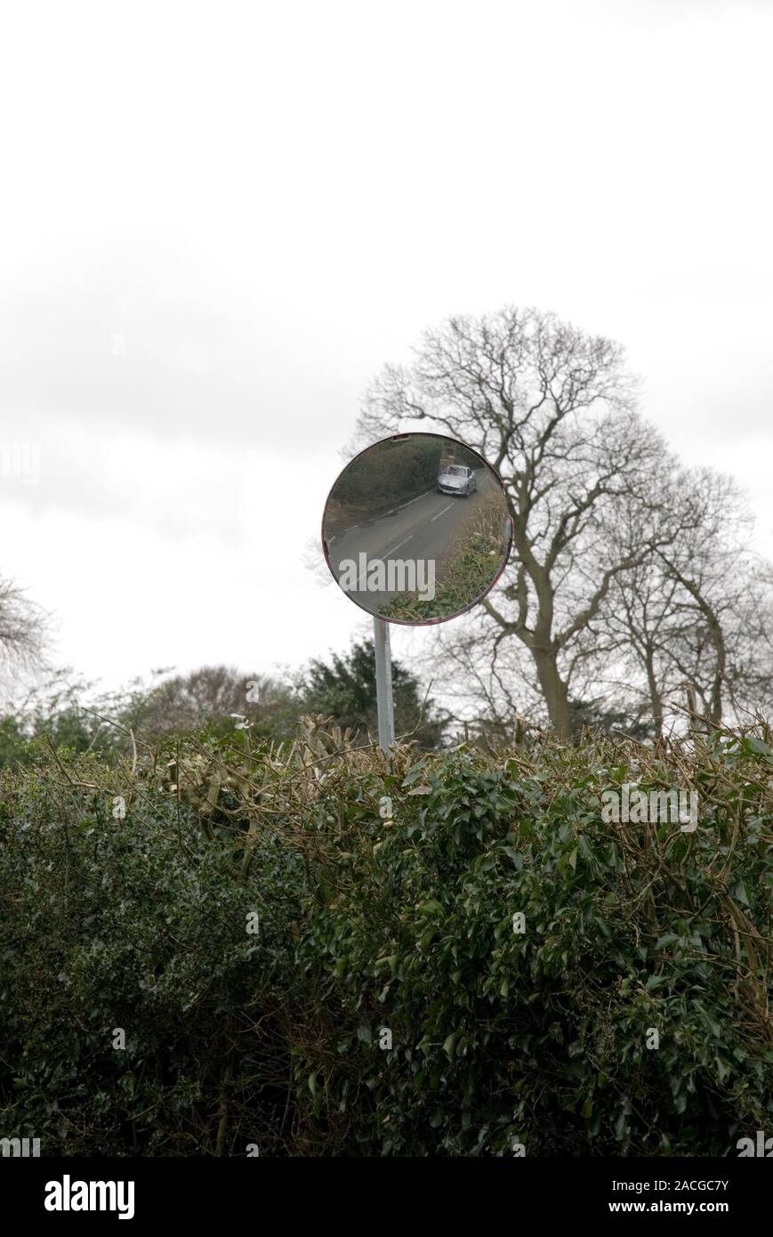 Traffic mirror in a hedge, with a reflection of a car Stock Photo - Alamy