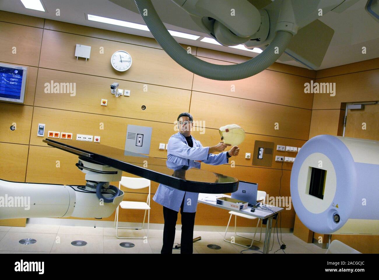 Particle therapy treatment room. Engineer installing a particle therapy ...