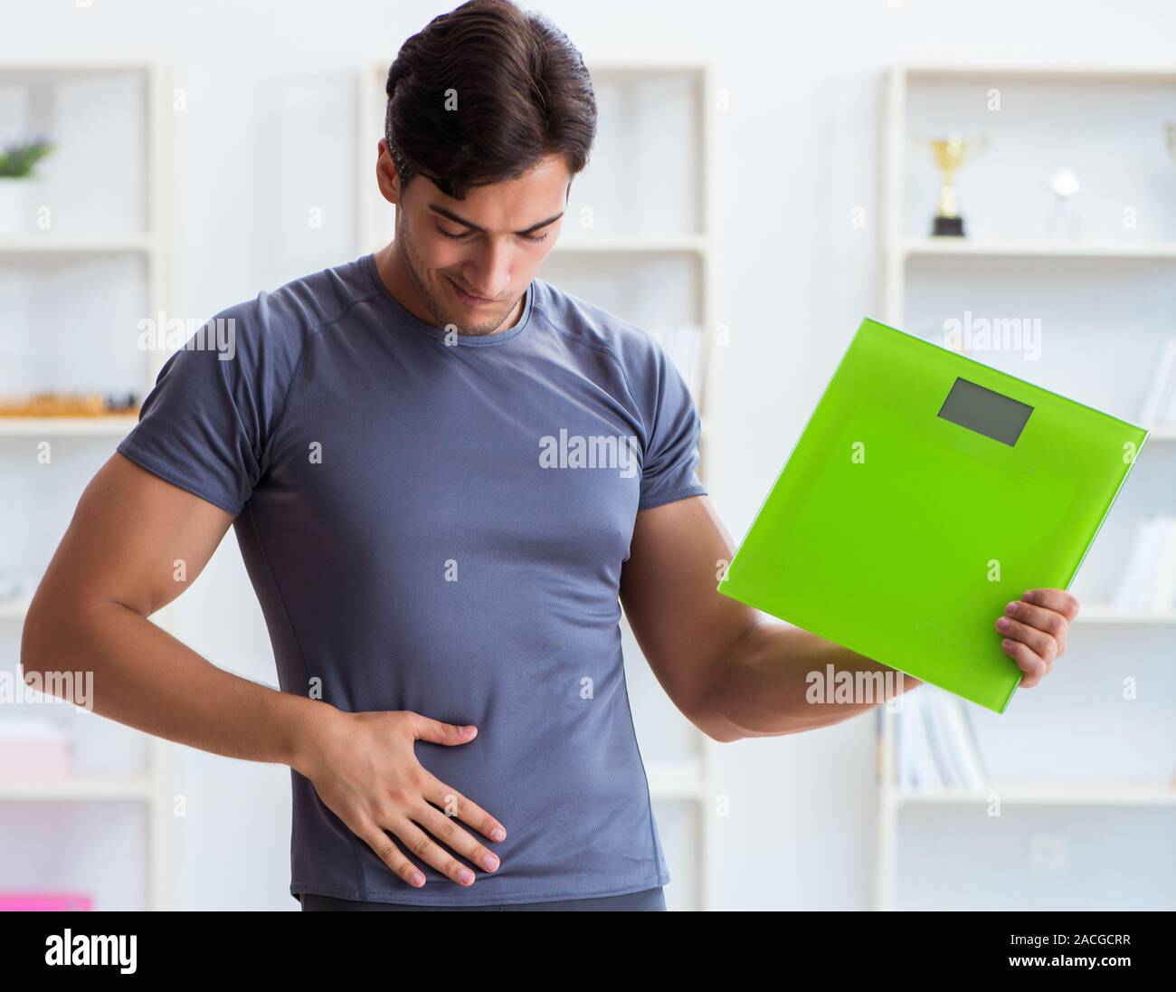 The man with scales in sports and health concept Stock Photo - Alamy