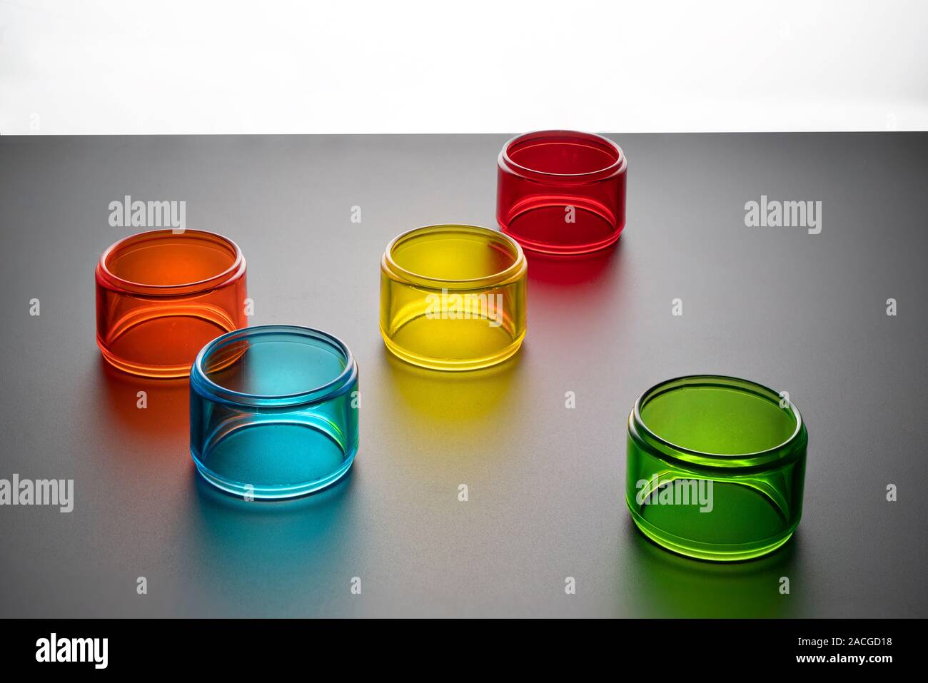 some colored containers on a black surface Stock Photo - Alamy
