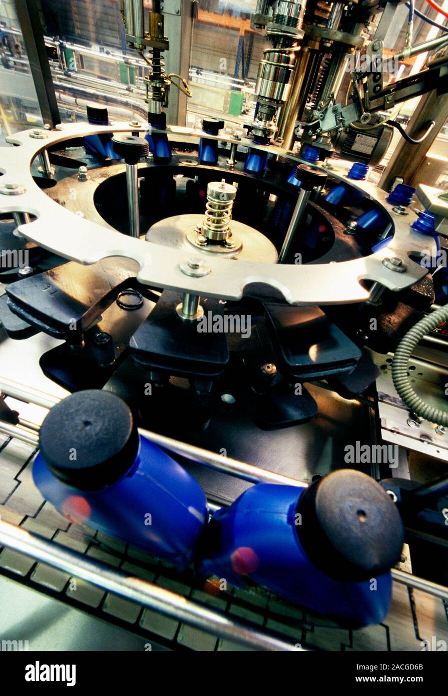 Factory production line. Close-up of bottles of oil being filled on the ...