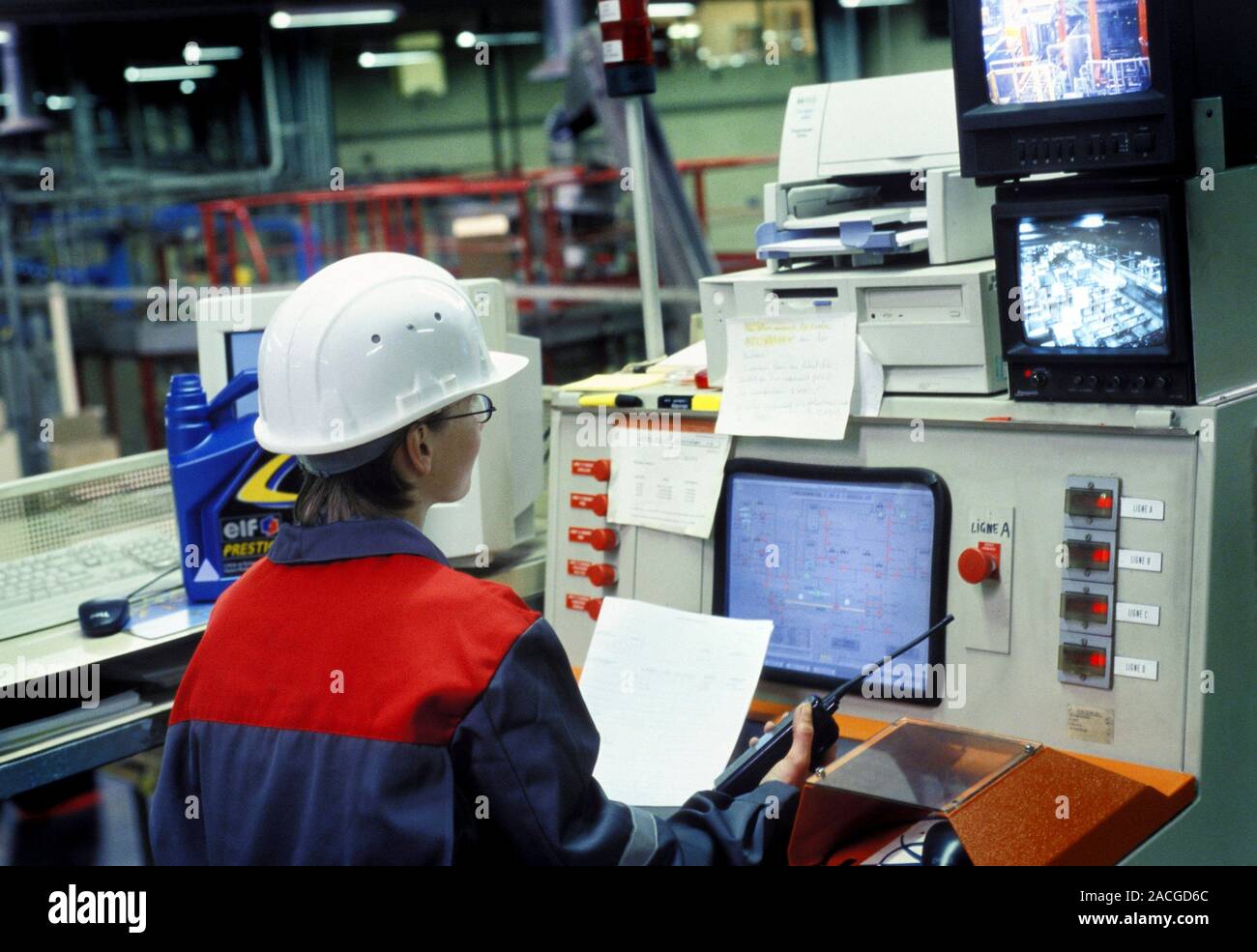 Factory production line. Factory worker at a control point on the ...