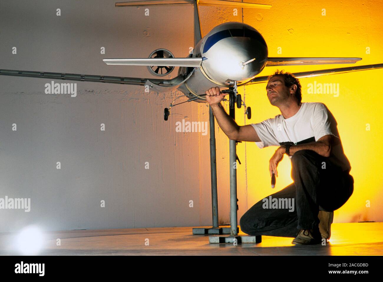 Aeroplane wind tunnel test. Technician preparing a 1/10 scale model of ...