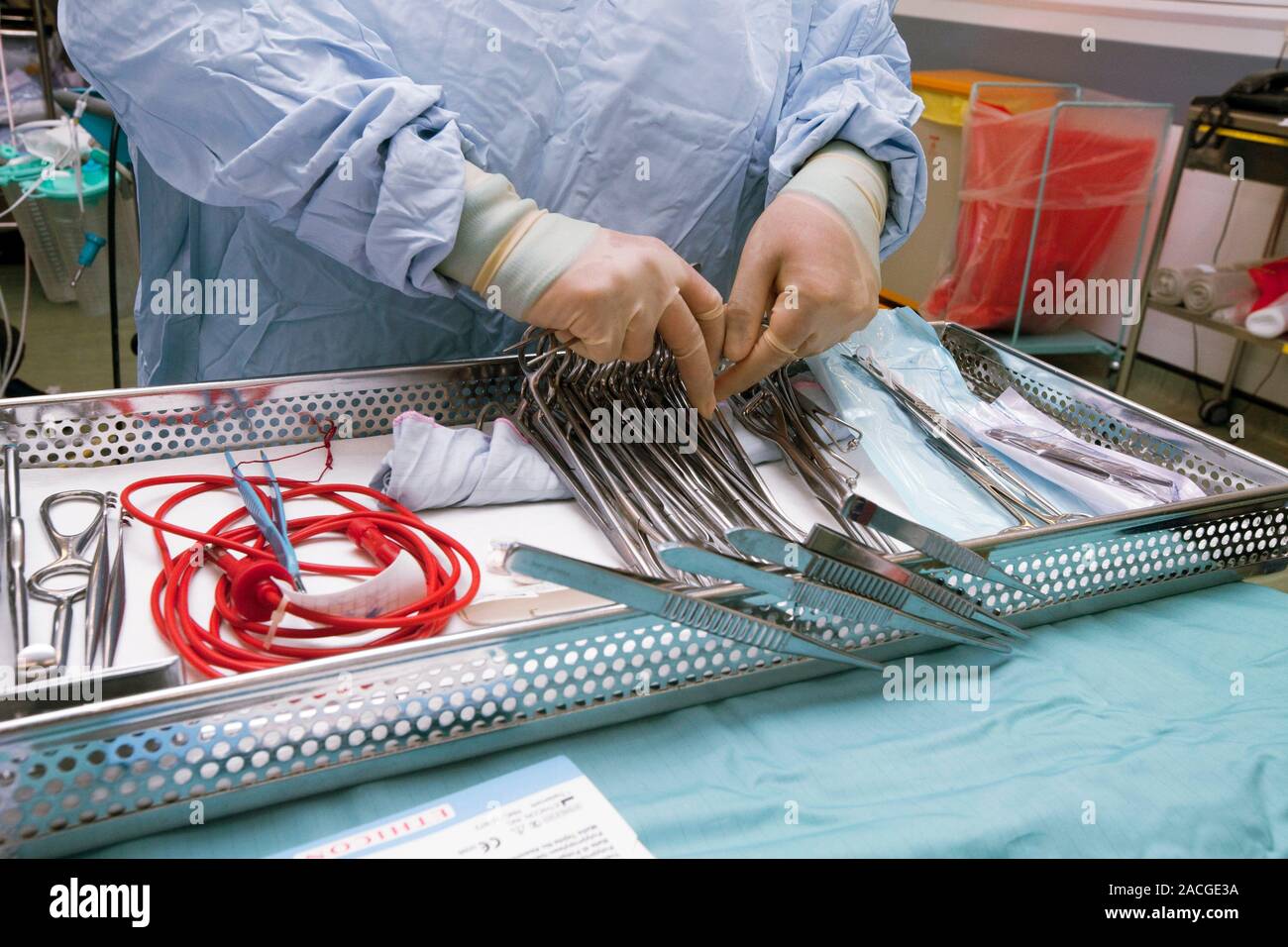 Surgeon with instruments. Surgeon laying out a tray of surgical ...