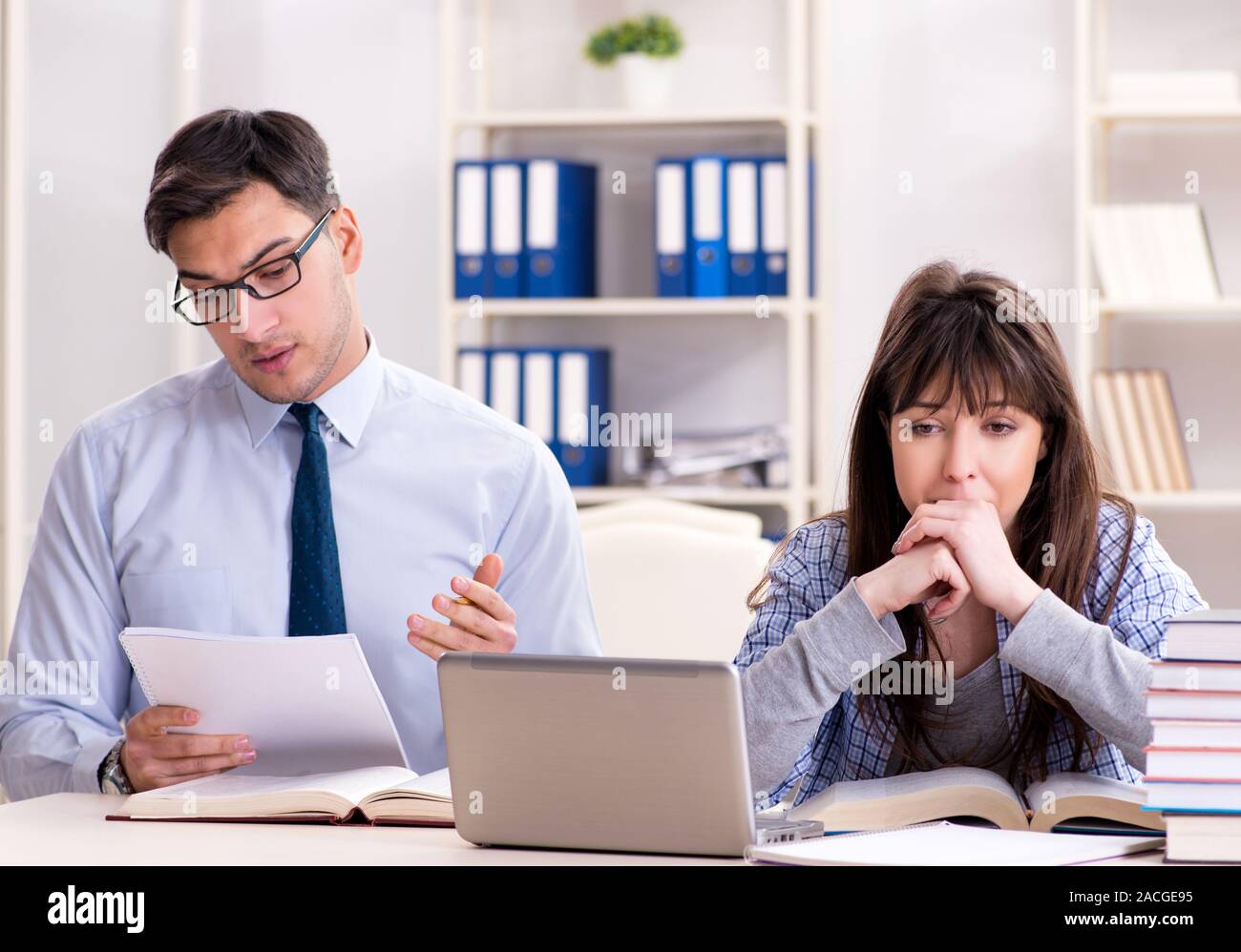 The male lecturer giving lecture to female student Stock Photo - Alamy