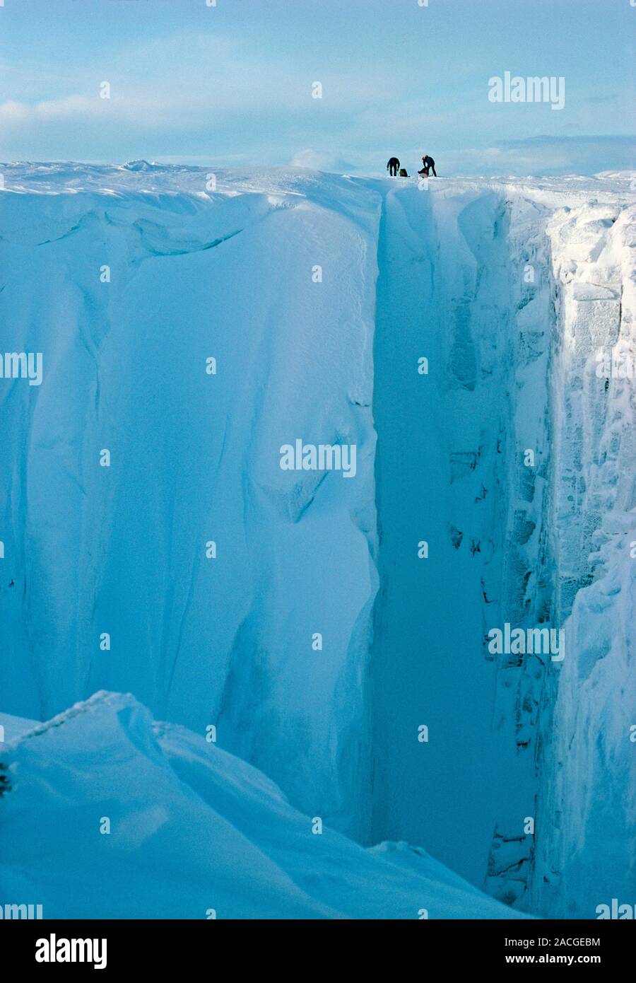 Ice cliffs. Climbers at the top of 1000 metre ice cliffs at the summit ...