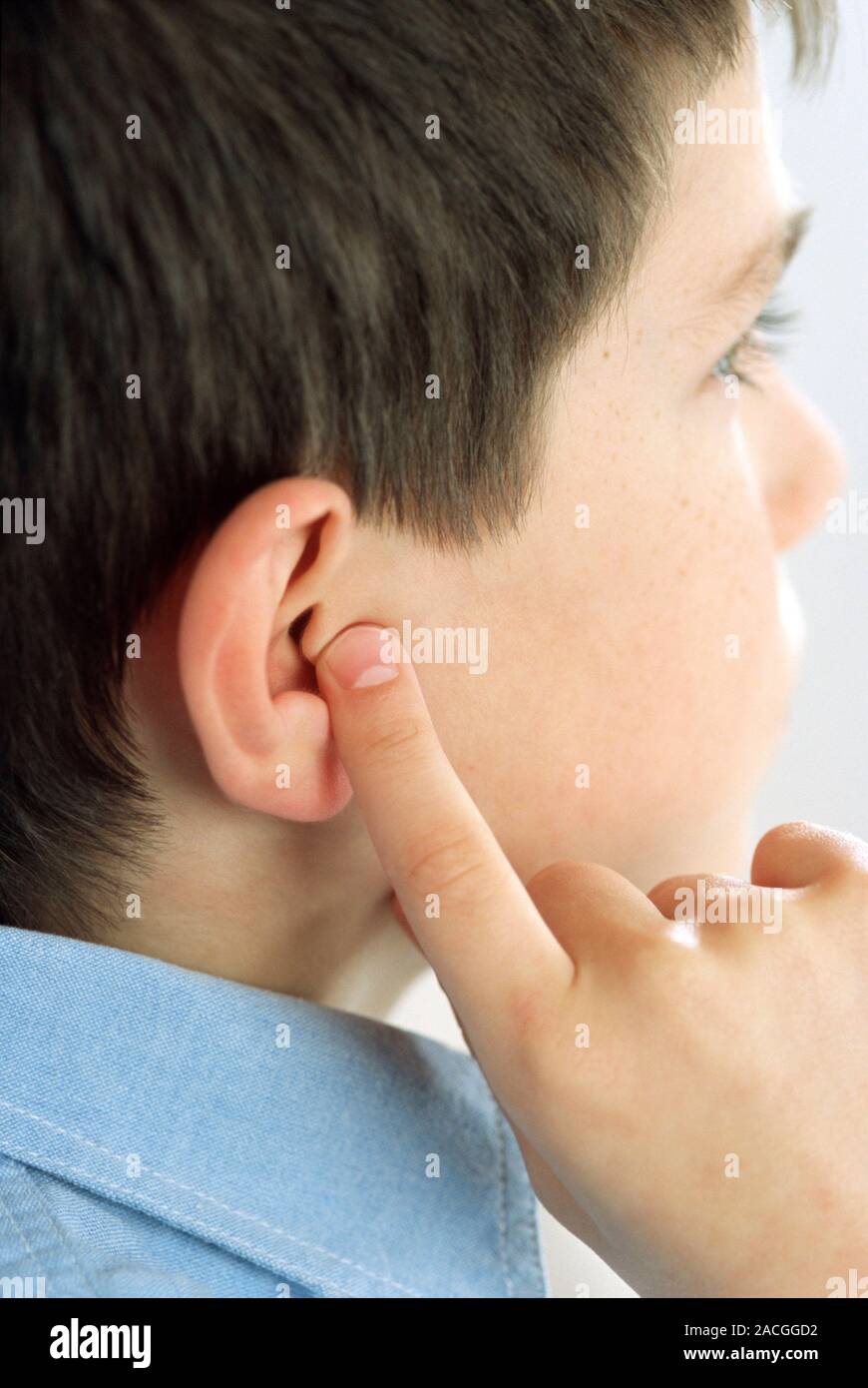 Ear ache. Boy touching his ear during a mild case of ear ache Stock ...