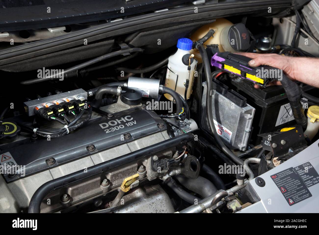 Liquefied petroleum gas engine conversion. Engineer connecting parts in ...