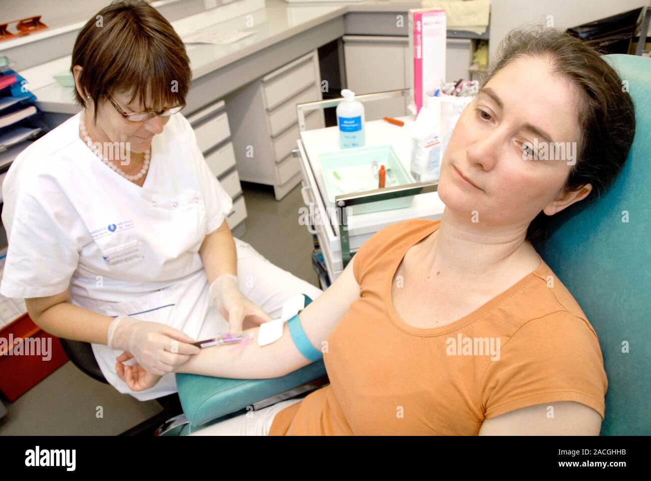 Taking a blood sample. Medical professional filling a test tube with ...