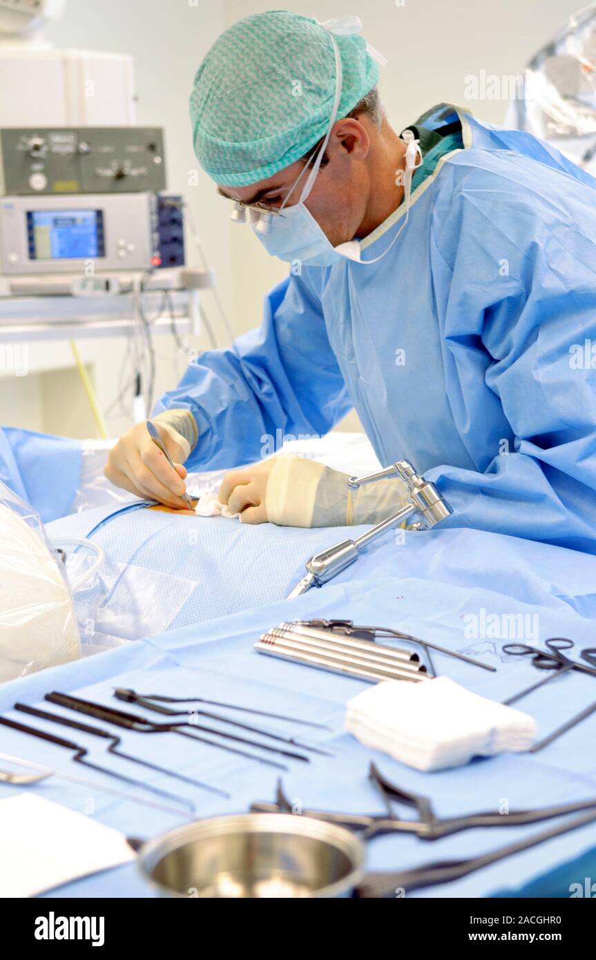 Slipped disc microendoscopy surgery. Surgeon performing an operation on ...
