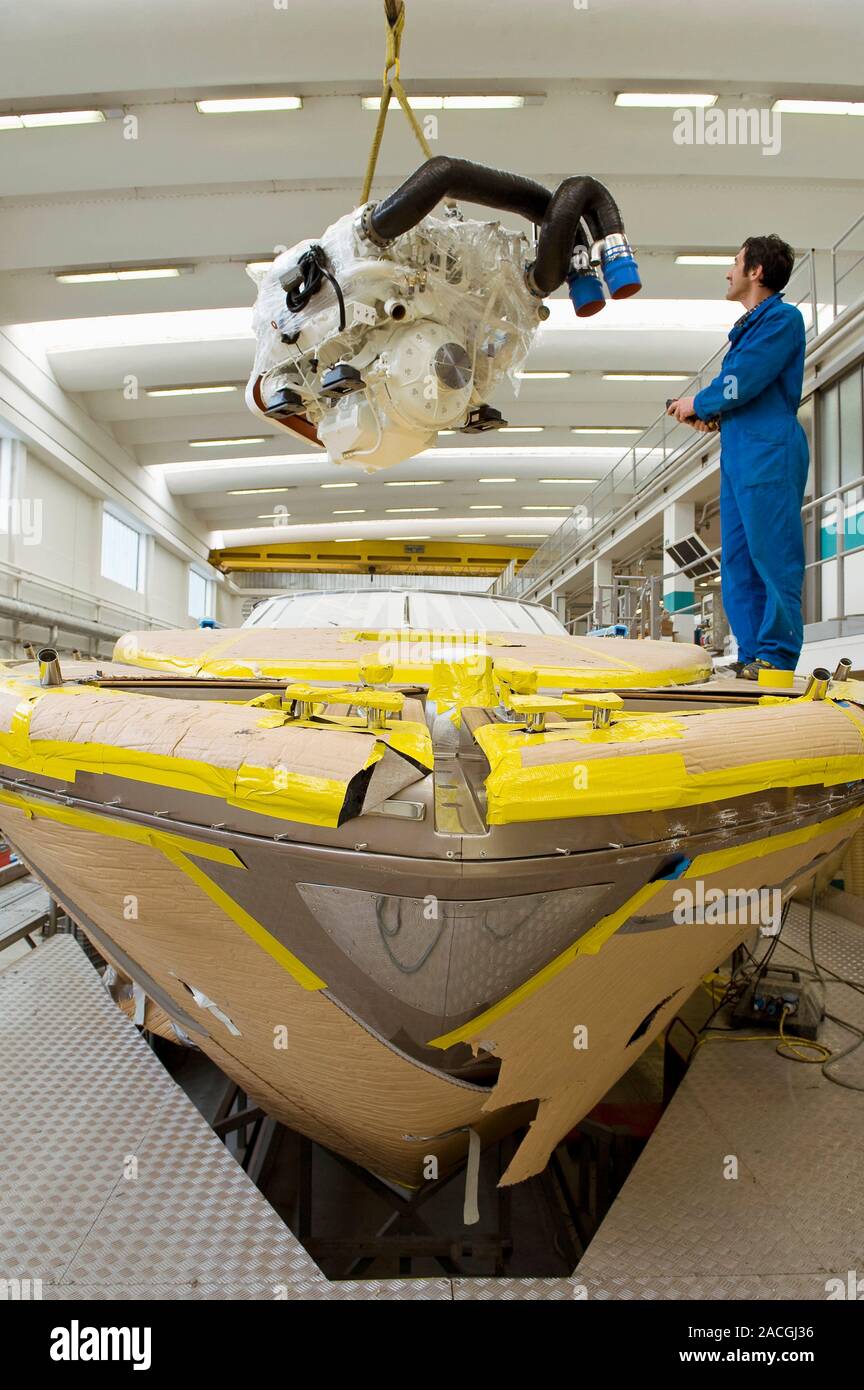Luxury boat building. Worker at the Riva boat yard building one of the ...