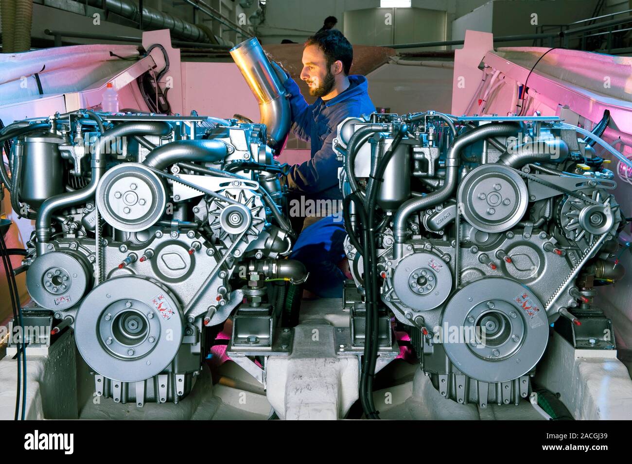 Luxury boat building. Worker installing engines in a luxury motoryacht ...
