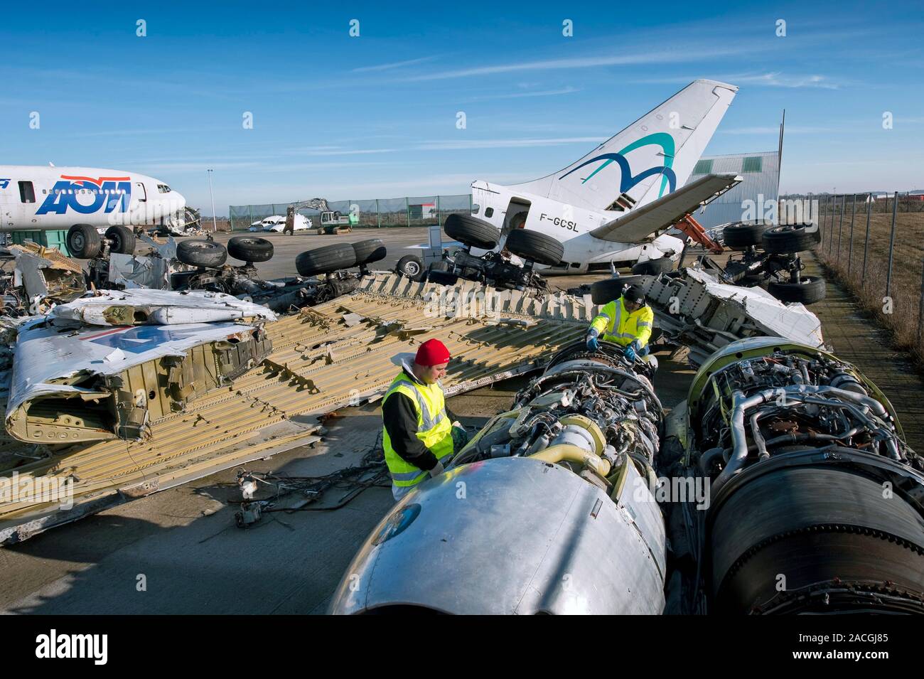 Aircraft dismantling. Workers dismantling the engines of a passenger ...