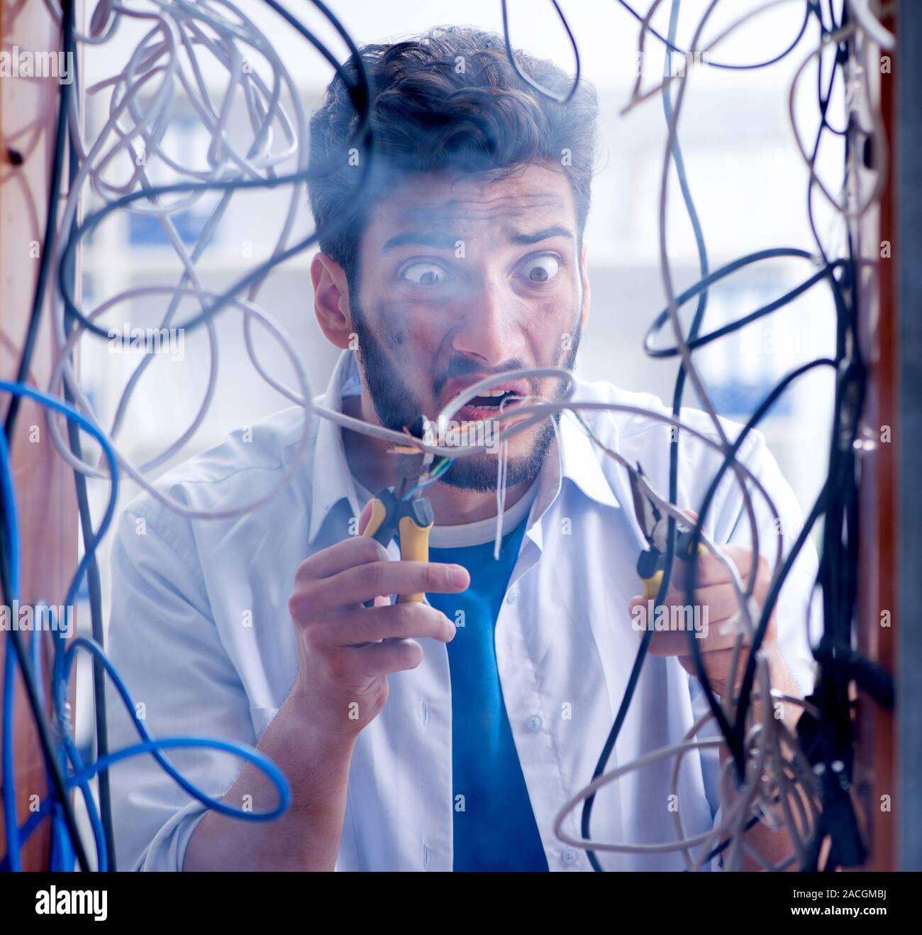 The electrician trying to untangle wires in repair concept Stock Photo ...