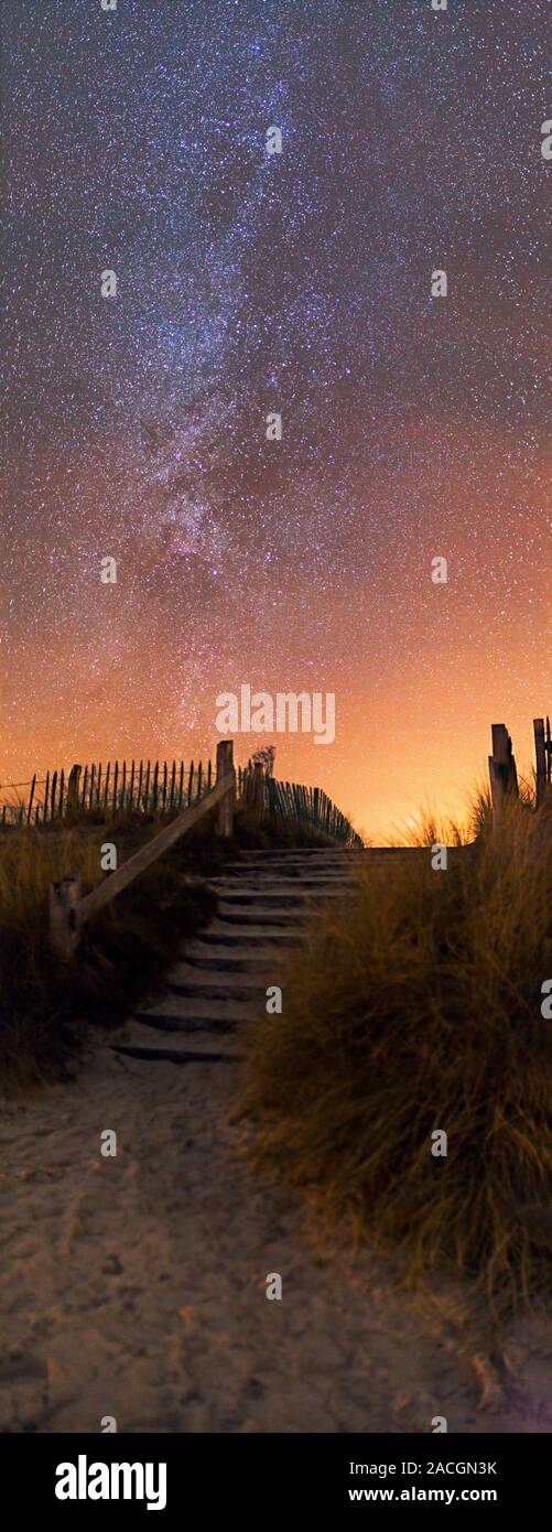 Stars in a night sky over a beach. The bright 'star' (upper right) is ...