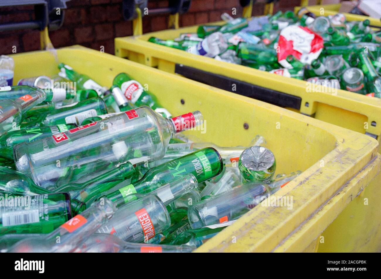 Glass bottle recycling. Bottles in recycling bins outside an entertainment venue. Photographed ...