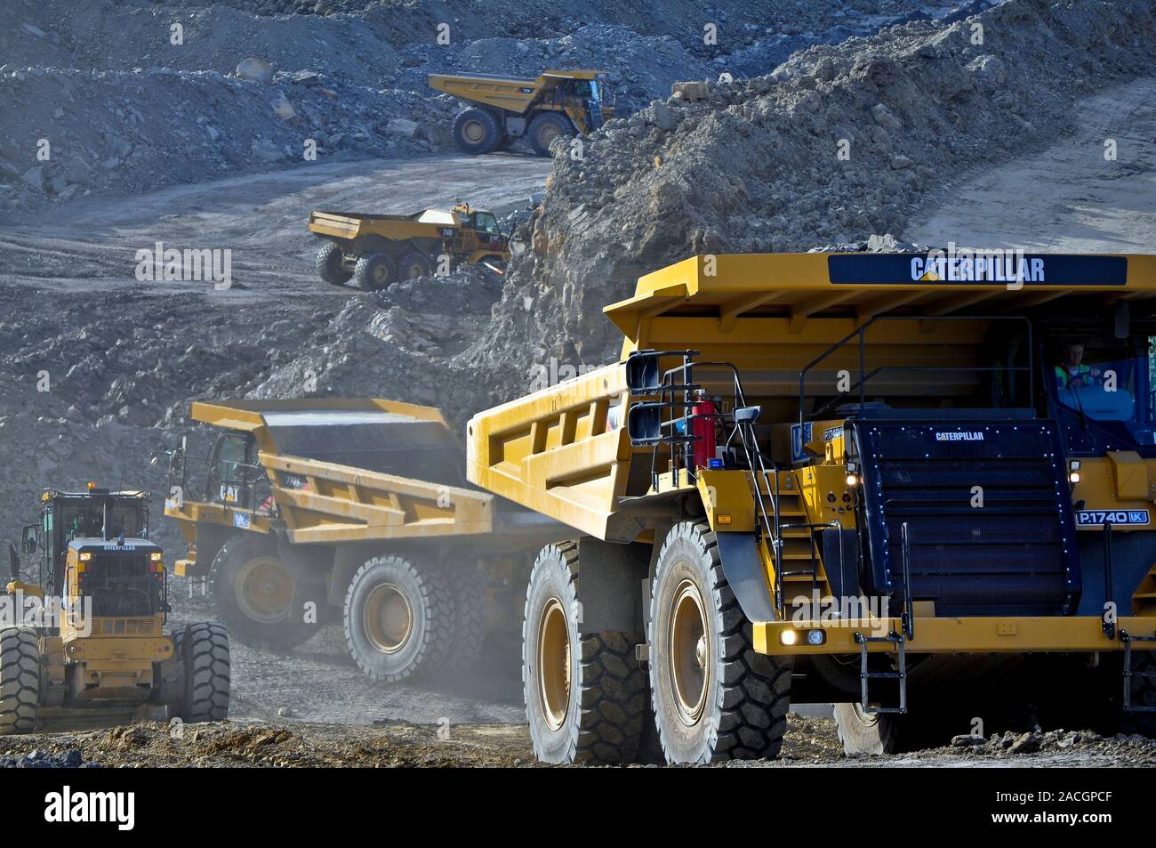Opencast coal mine. Trucks carrying coal excavated from a surface mine ...