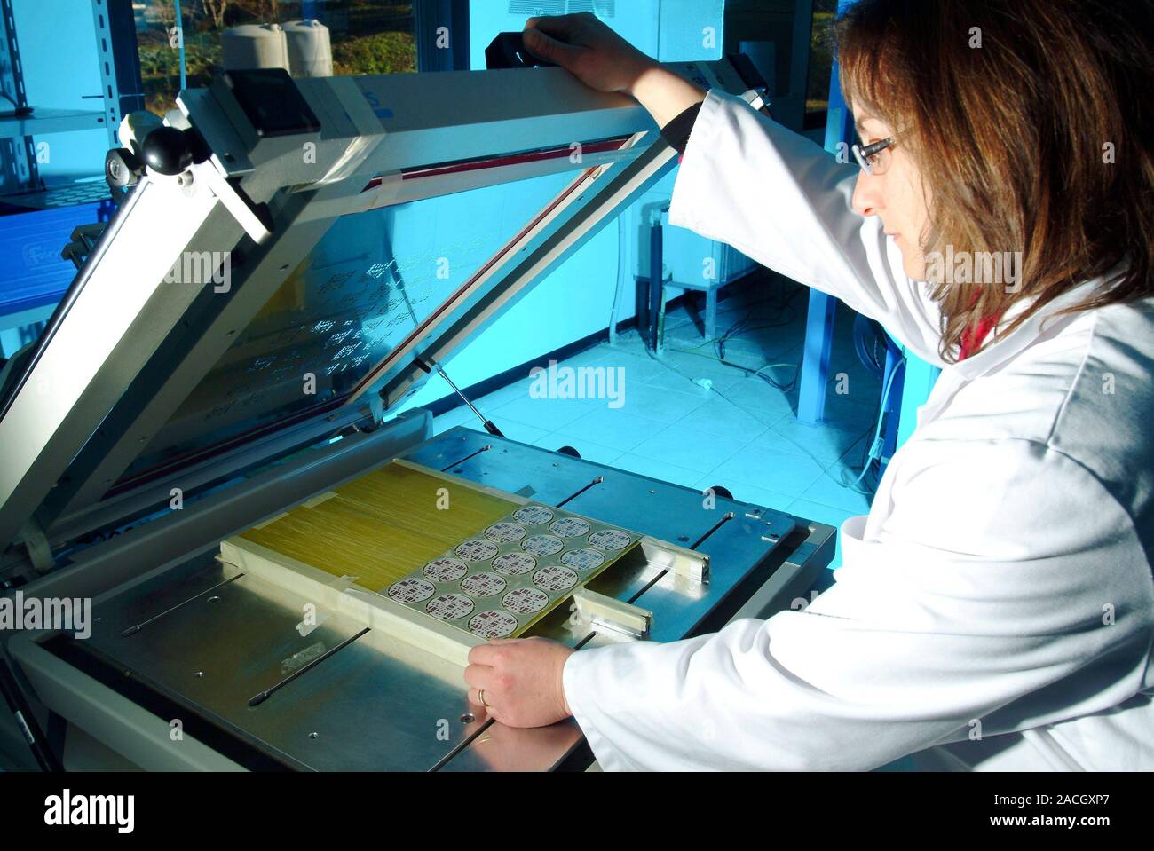 LED street lighting. Technician using a screen printing machine to make ...