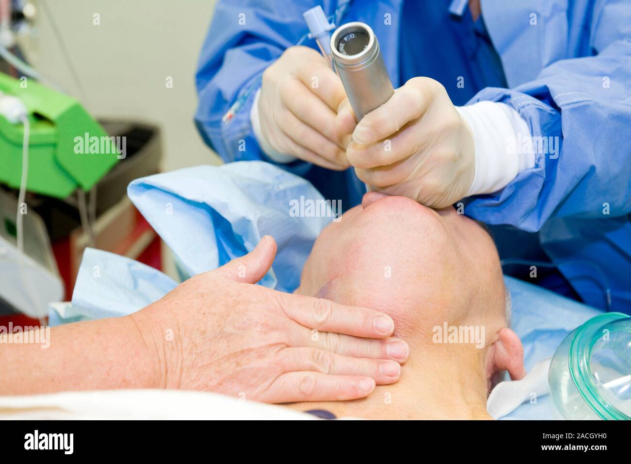 Intubating a patient. Doctor inserting a breathing tube into a patient ...