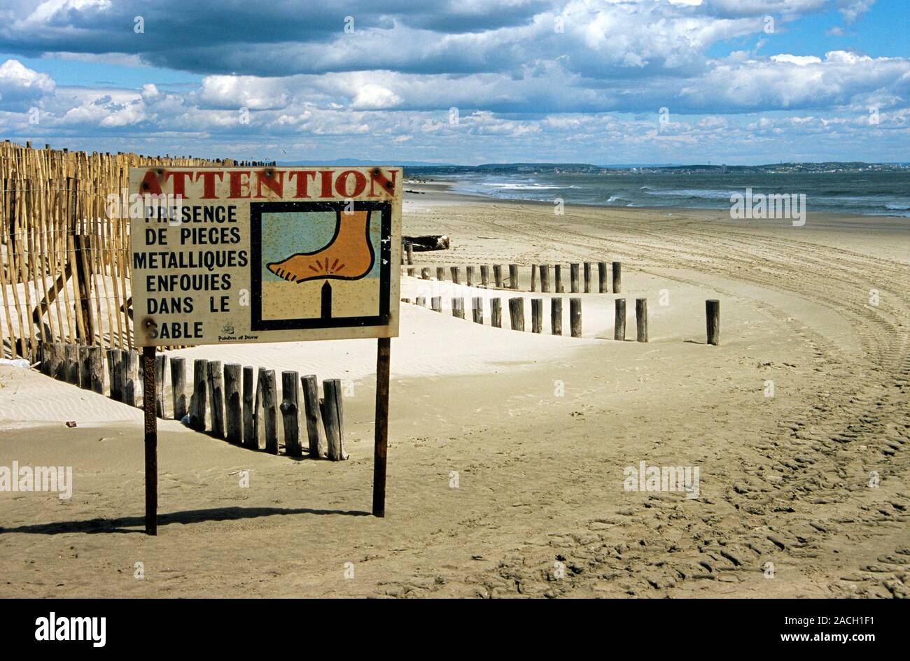 Polluted beach warning sign, telling walkers to beware of sharp metal ...