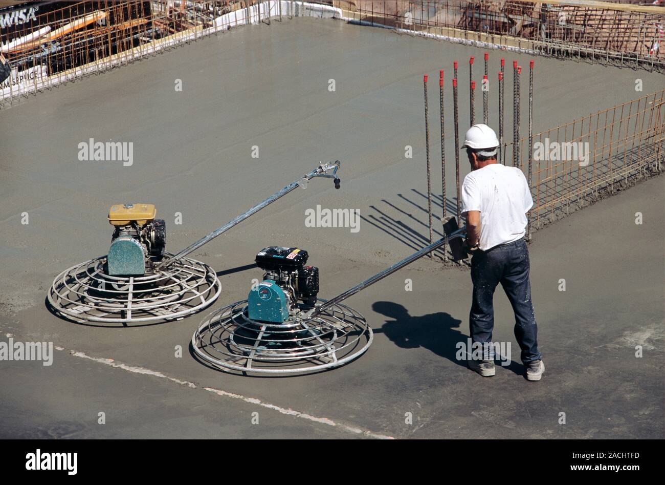 Concrete floor construction. Building worker using a rotary concrete ...