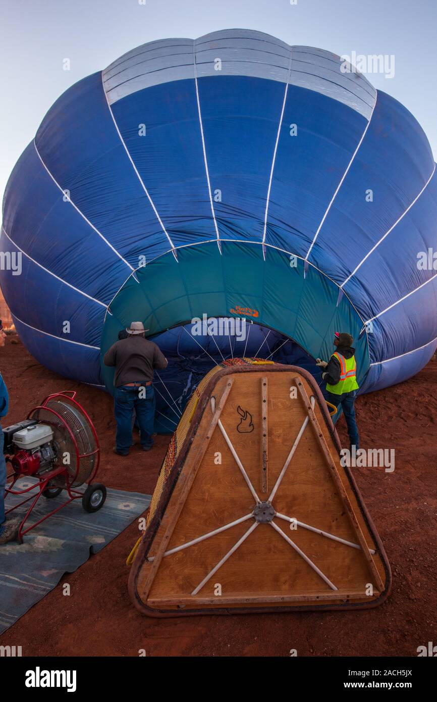 A hot air balloon fills with air from a large fan in preparation for ...