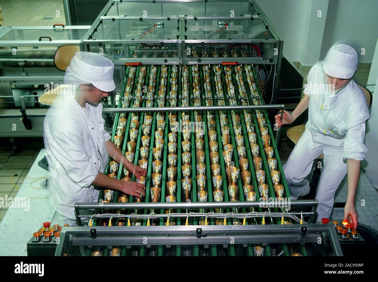Ice cream factory. Workers checking finished ice cream cones at an ...