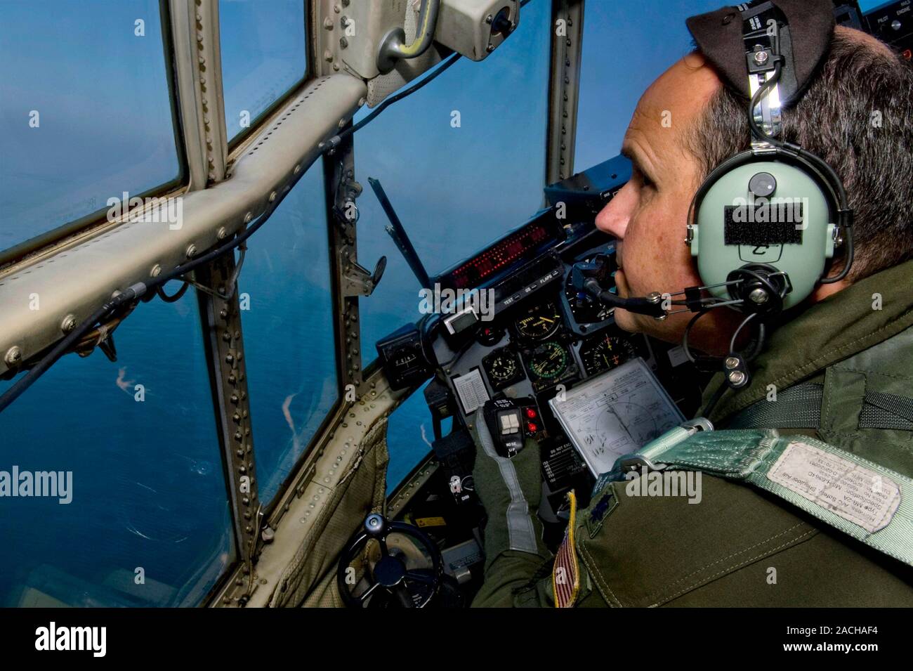 Oil spill dispersal. Pilot flying a c-130 Hercules aircraft on a ...