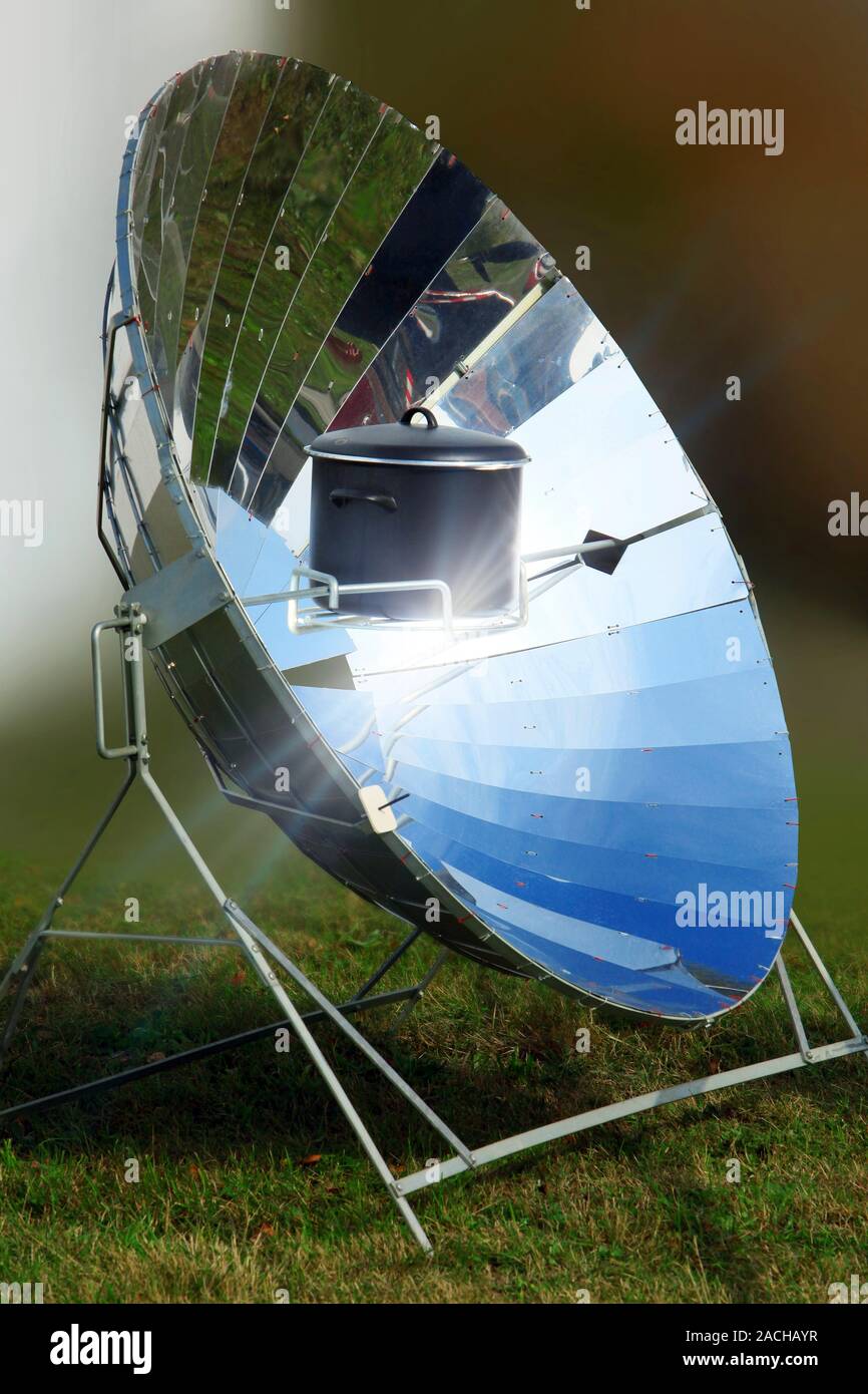 Parabolic solar cooker. Cooking pot being heated on a parabolic solar ...