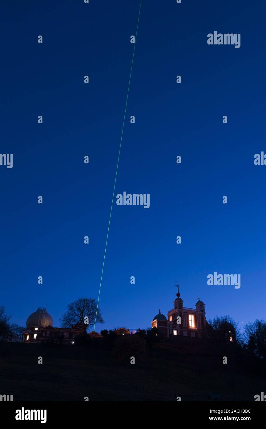 Royal Observatory, Greenwich, UK at night. A laser beam projecting from ...