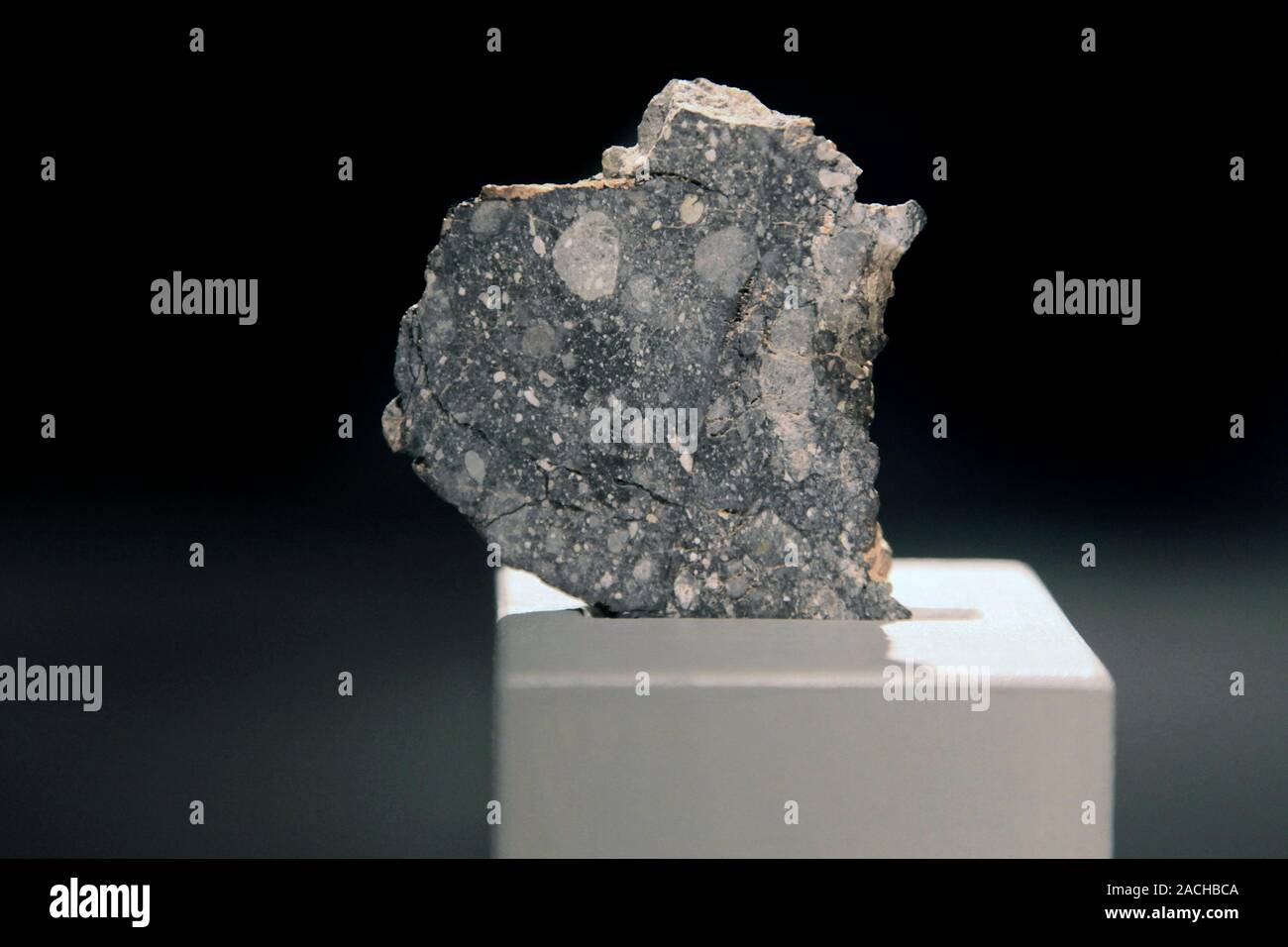 Lunar meteorite on a display stand. This 6-centimetre-long fragment of ...